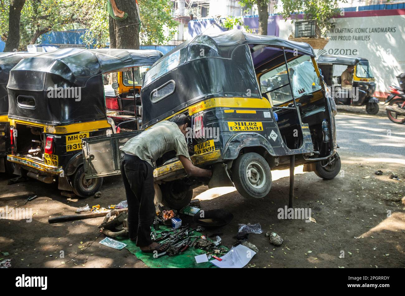 Auto Rickshaw Drivers and mechanics fixing their vehicles in the ...
