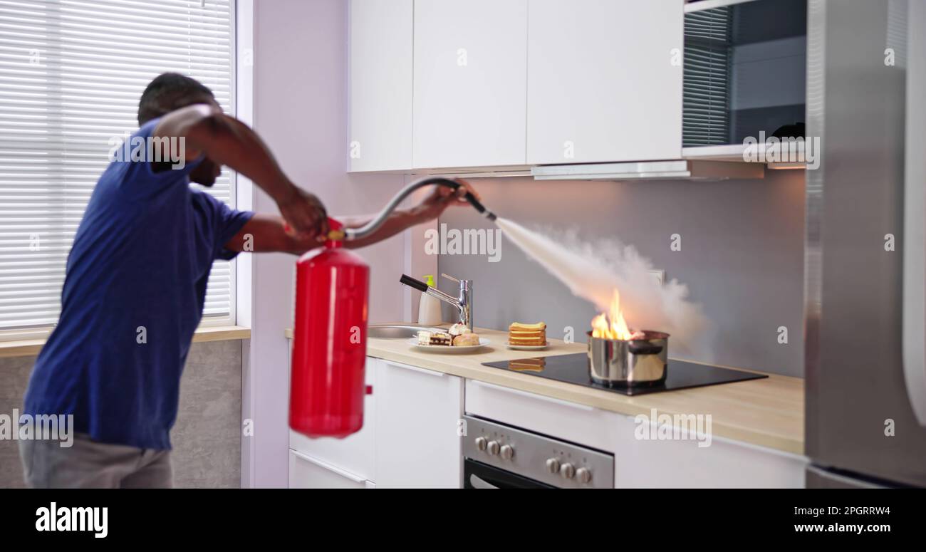 Man Using Fire Extinguisher To Stop Fire On Burning Cooking Pot In The ...