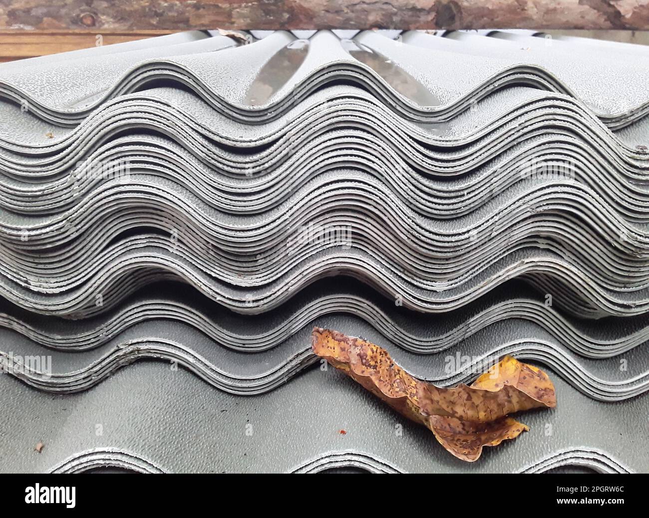 Grey ondulin stack. A pile of wet, plastic roofing material Stock Photo ...