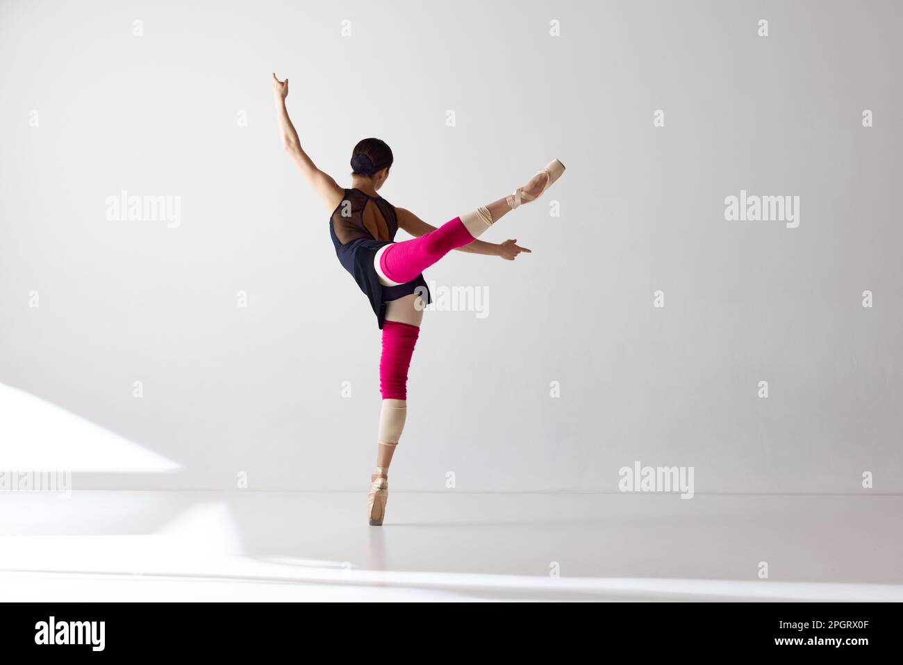 Back view. Ballet dancer standing wearing pointe shoes dancing on ...