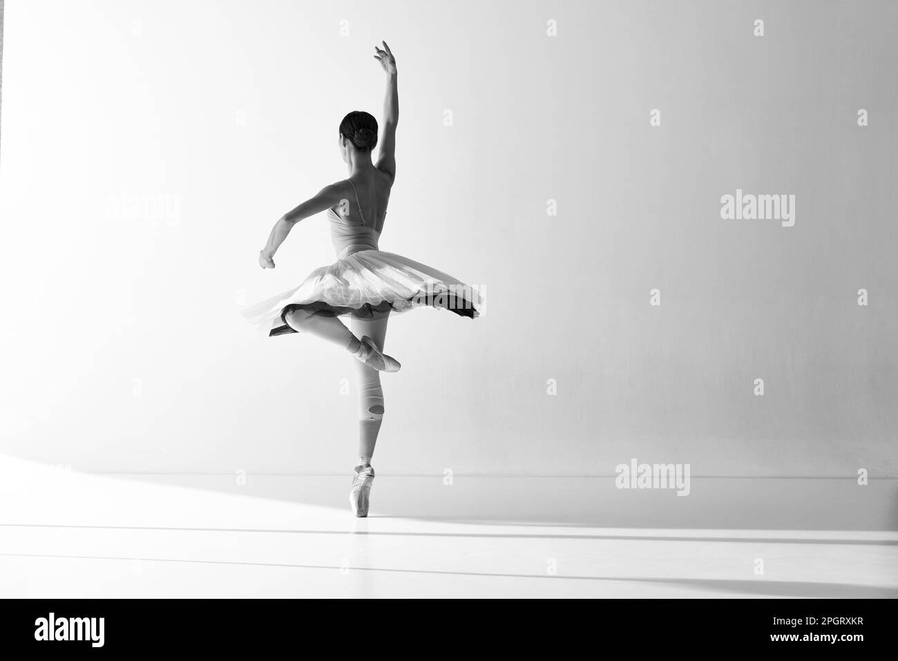 Monochrome. Ballerina wearing tutu poses in motion showing ballet ...
