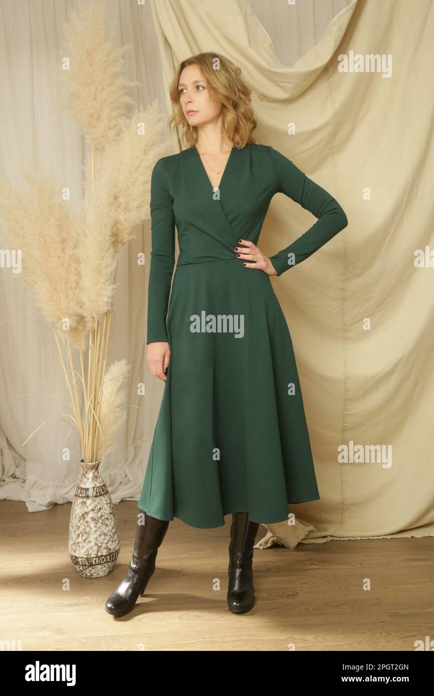 Serie of studio photos of young female model in green elegant midi ...