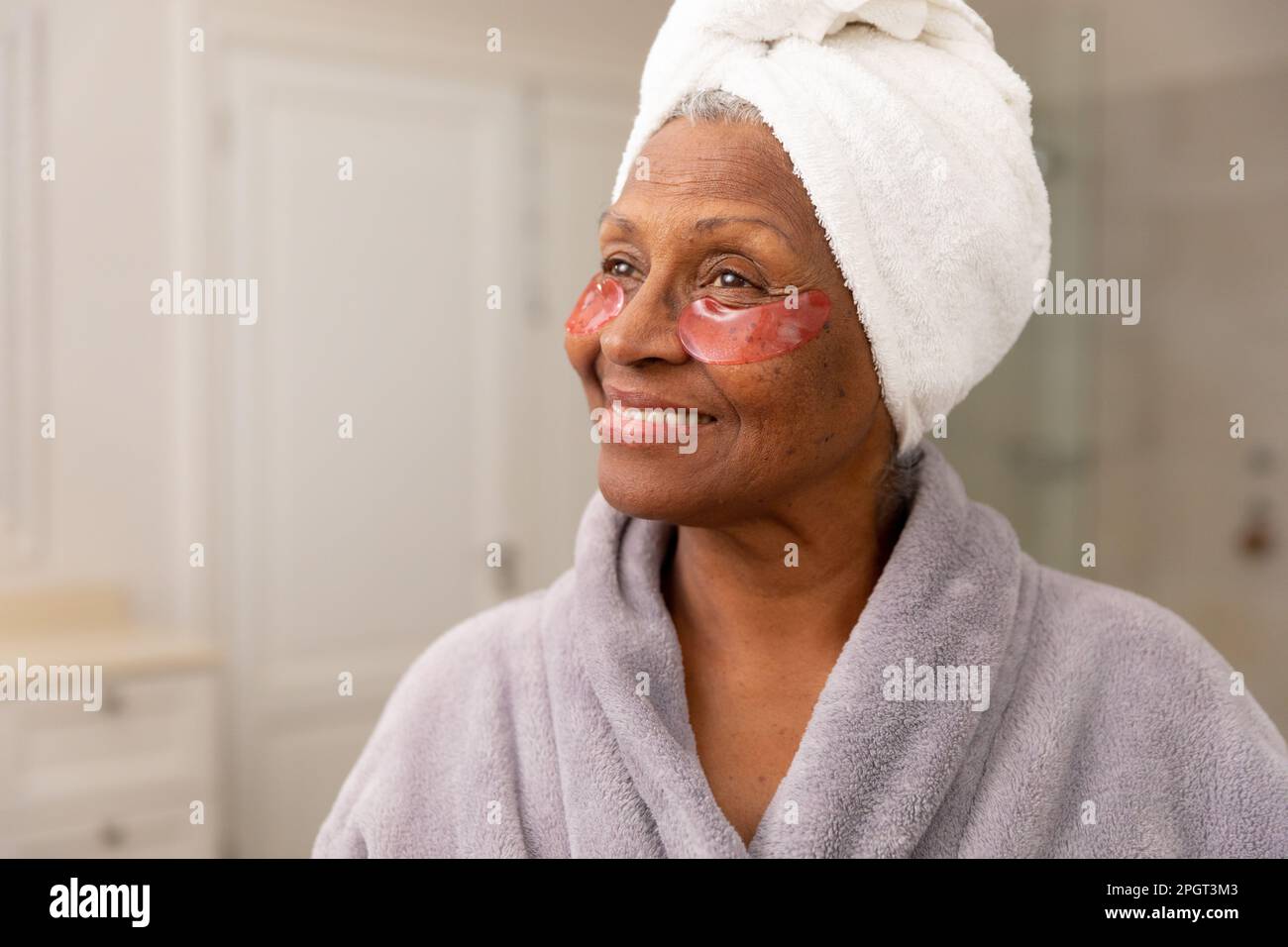 Closeup of smiling african american senior woman with eye patches under ...