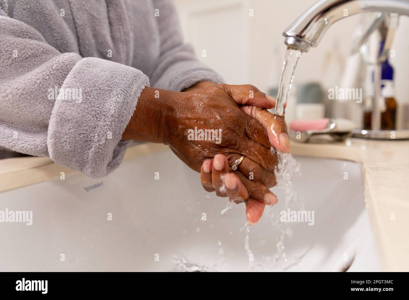 Midsection of african american senior woman washing hands under running ...