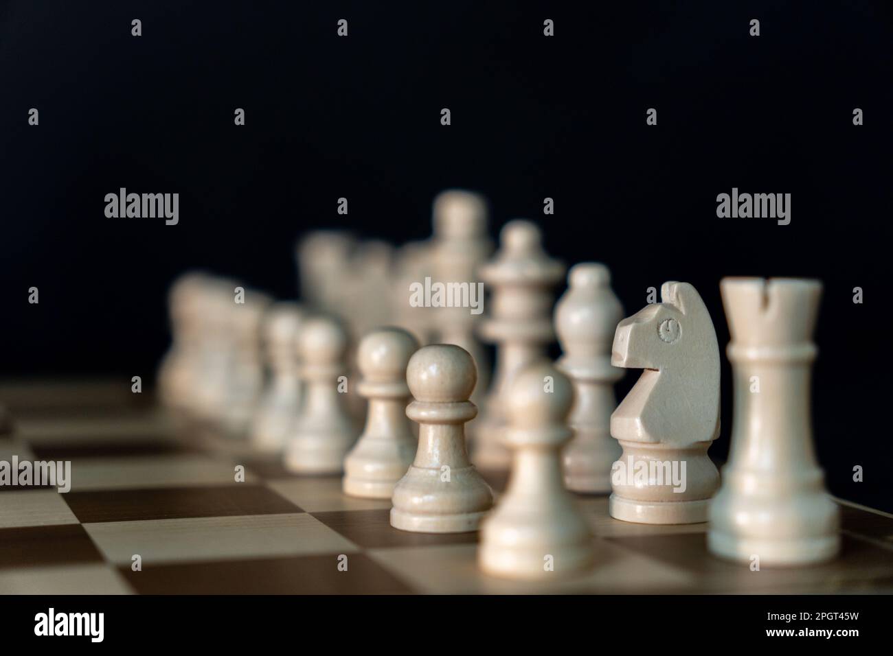 A closeup of a chessboard set up in its beginning position featuring ...