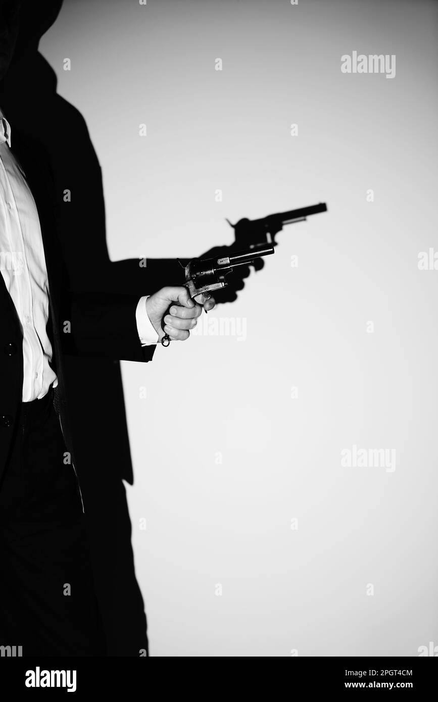 Retro secret agent with pistol revolver gun in hand in vintage crime ...