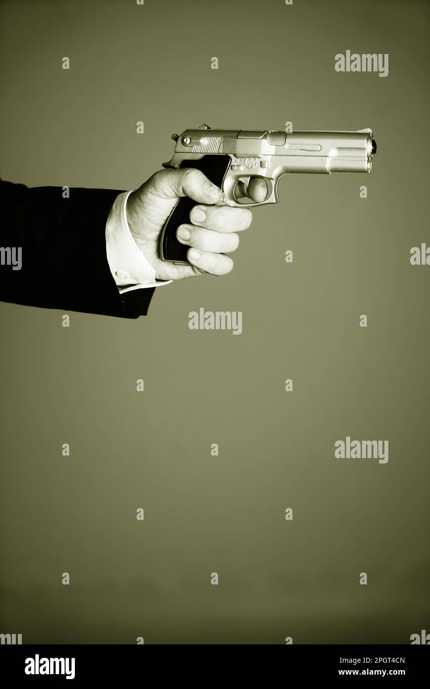 Retro secret agent with pistol revolver gun in hand in vintage crime ...