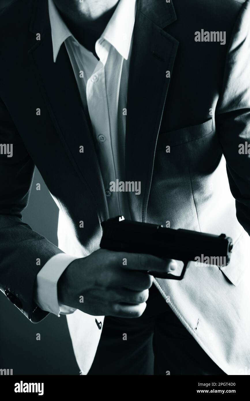 Retro secret agent with pistol revolver gun in hand in vintage crime ...