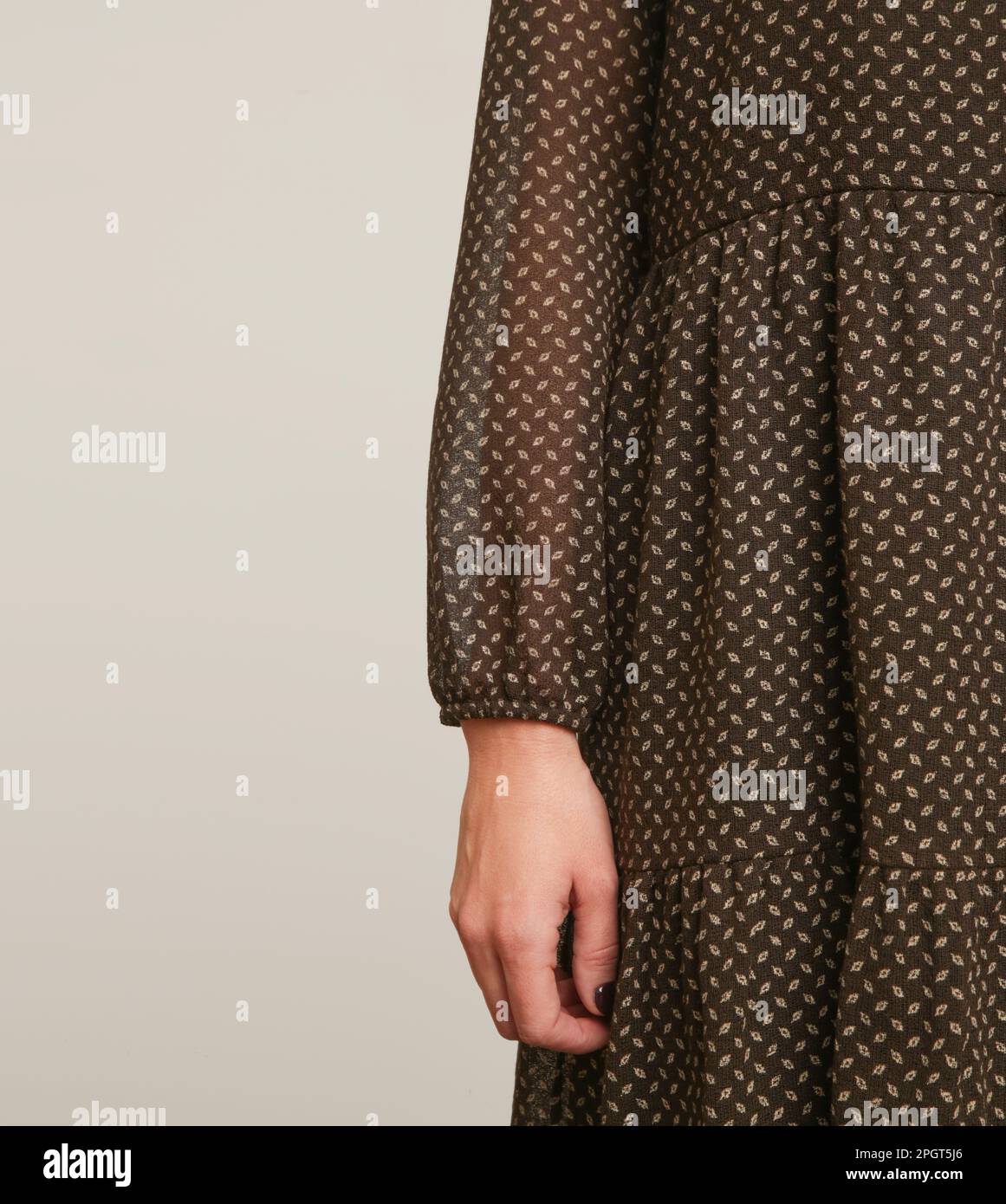 Serie of studio photos of young female model in brown patterned dress ...