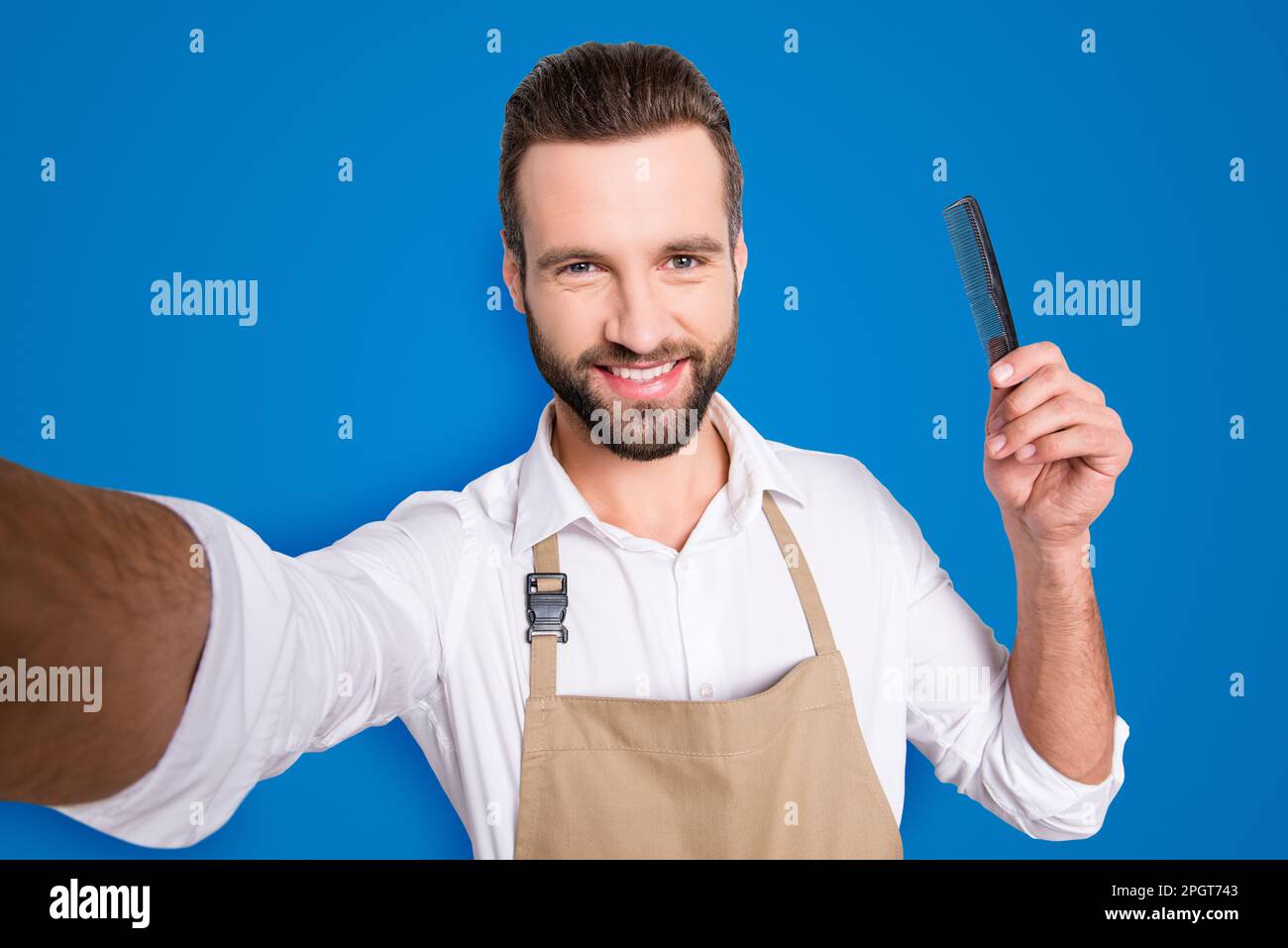 Self portrait of cheerful joyful barber shooting selfie on front camera ...
