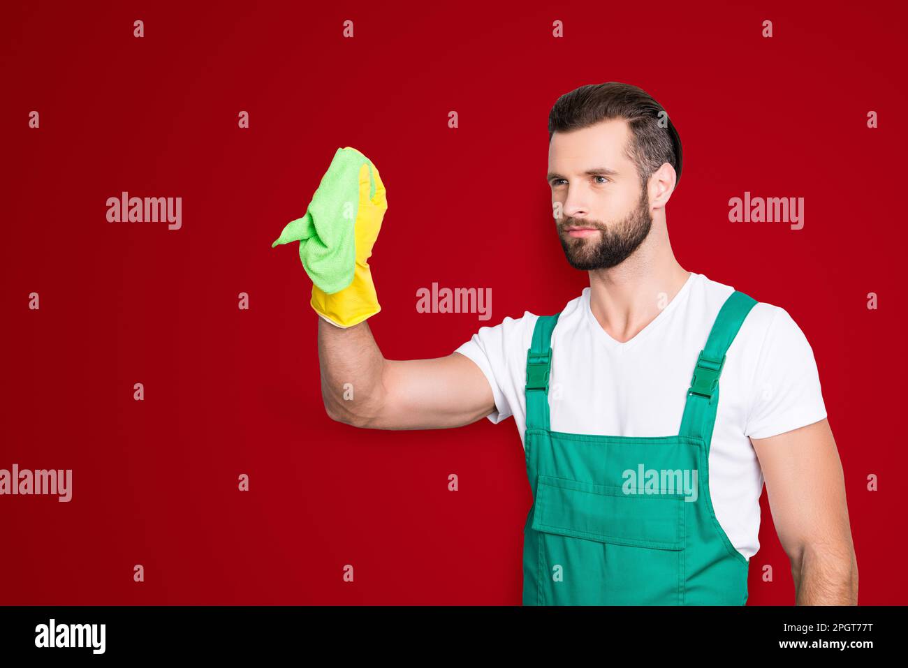 Portrait of busy concentrated housekeeper with stubble in uniform ...