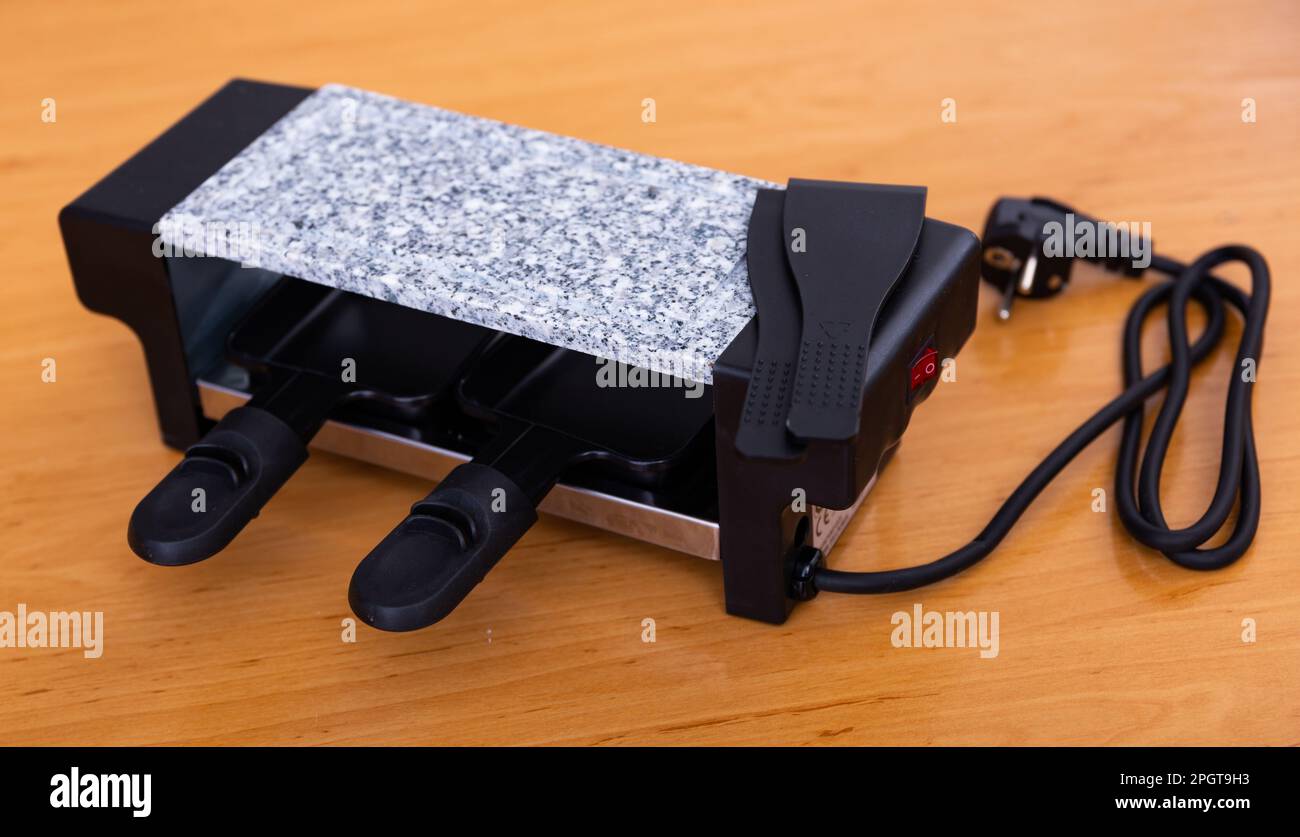 Table-top grill involved in serving swiss dish of raclette Stock Photo ...