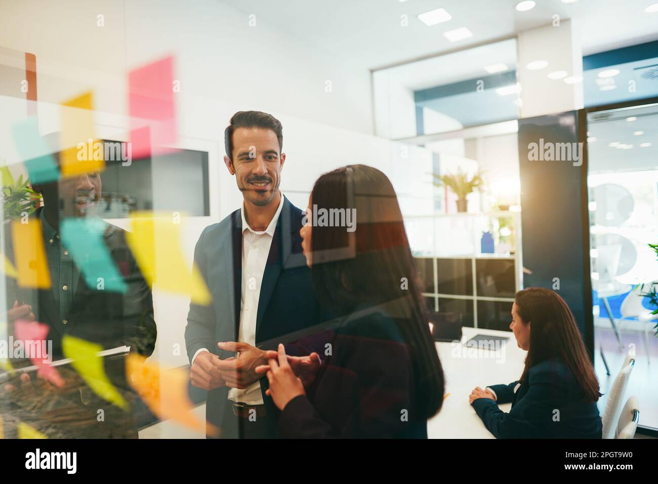Multiracial colleagues working inside business office with glass walls ...