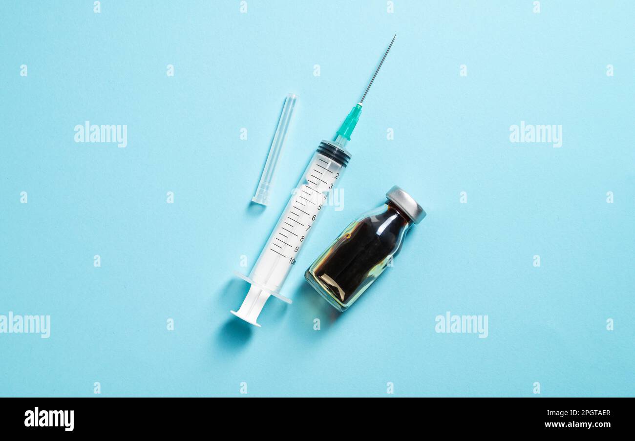 Transparent plastic syringe on blue background with empty copy space ...