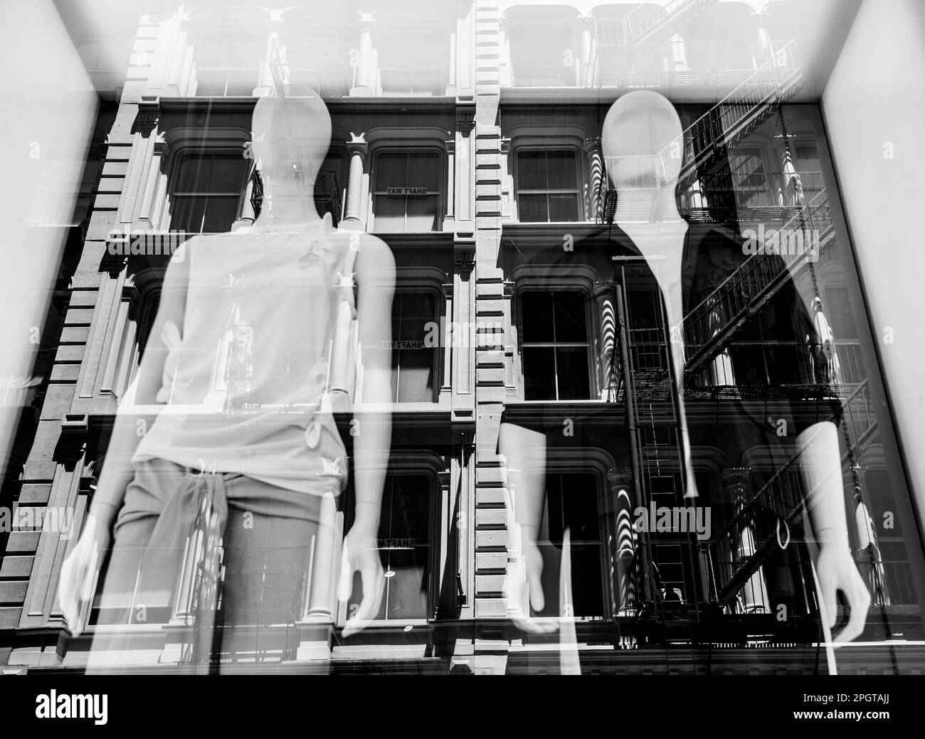 Fashion mannequins in a shop window with a reflection of a house ...