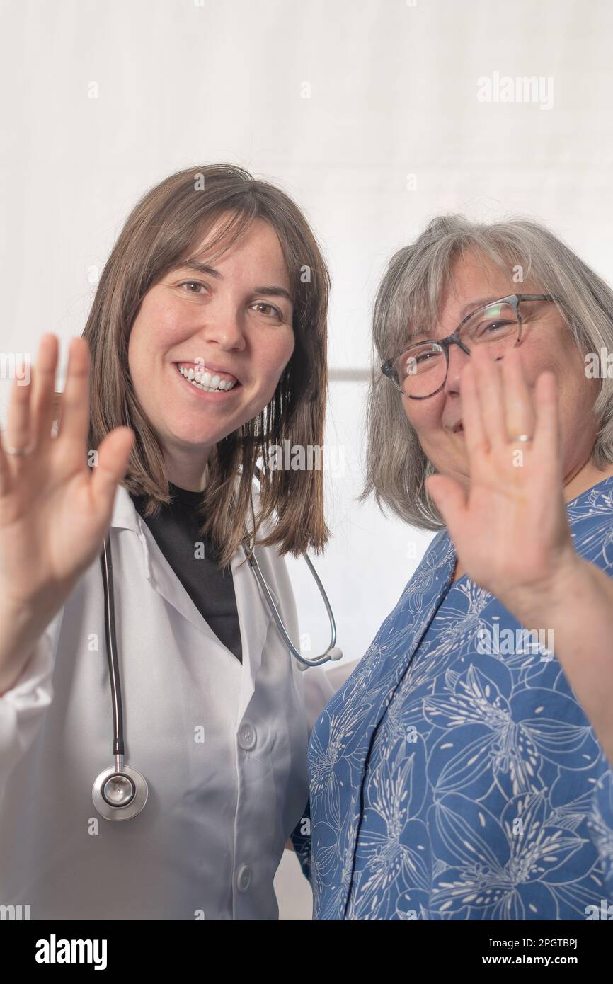 woman doctor and patient greeting the camera happy and smiling in the ...