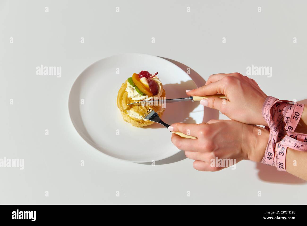 Top view of female hands tasting sweets with bound hands over white ...