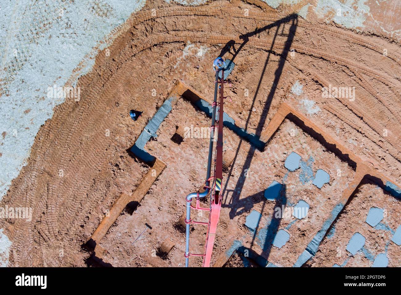 Construction worker using concrete pump to pour concrete into ...