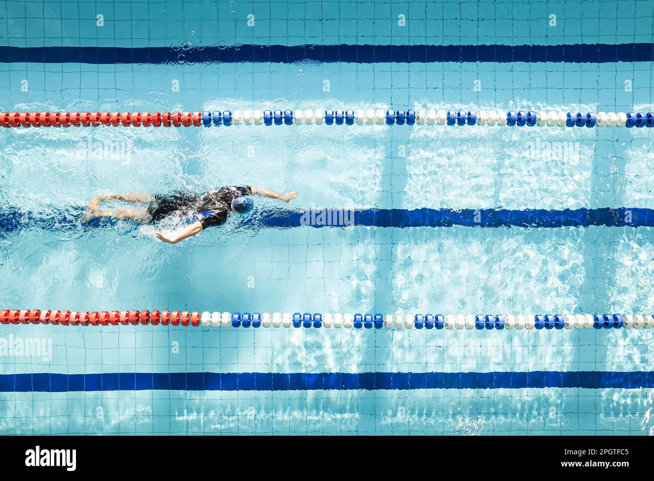 Top view shot of young man swimming laps in swimming pool. Male swimmer ...