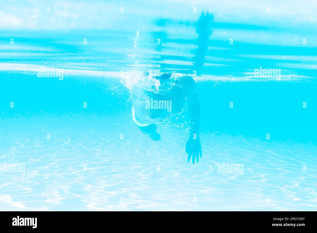 young man swimming the front crawl style in a pool Stock Photo - Alamy