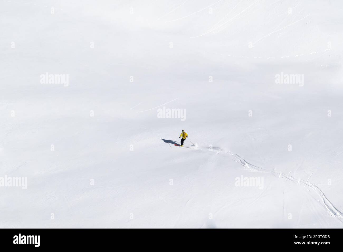 Single freeriding skier making fresh first tracks in recent powder snow ...