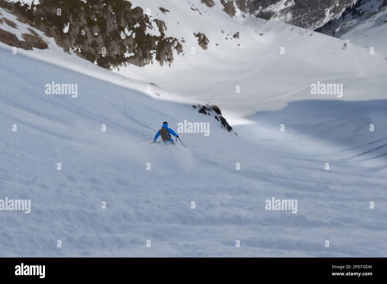 Single freeriding skier making fresh first tracks in recent powder snow ...