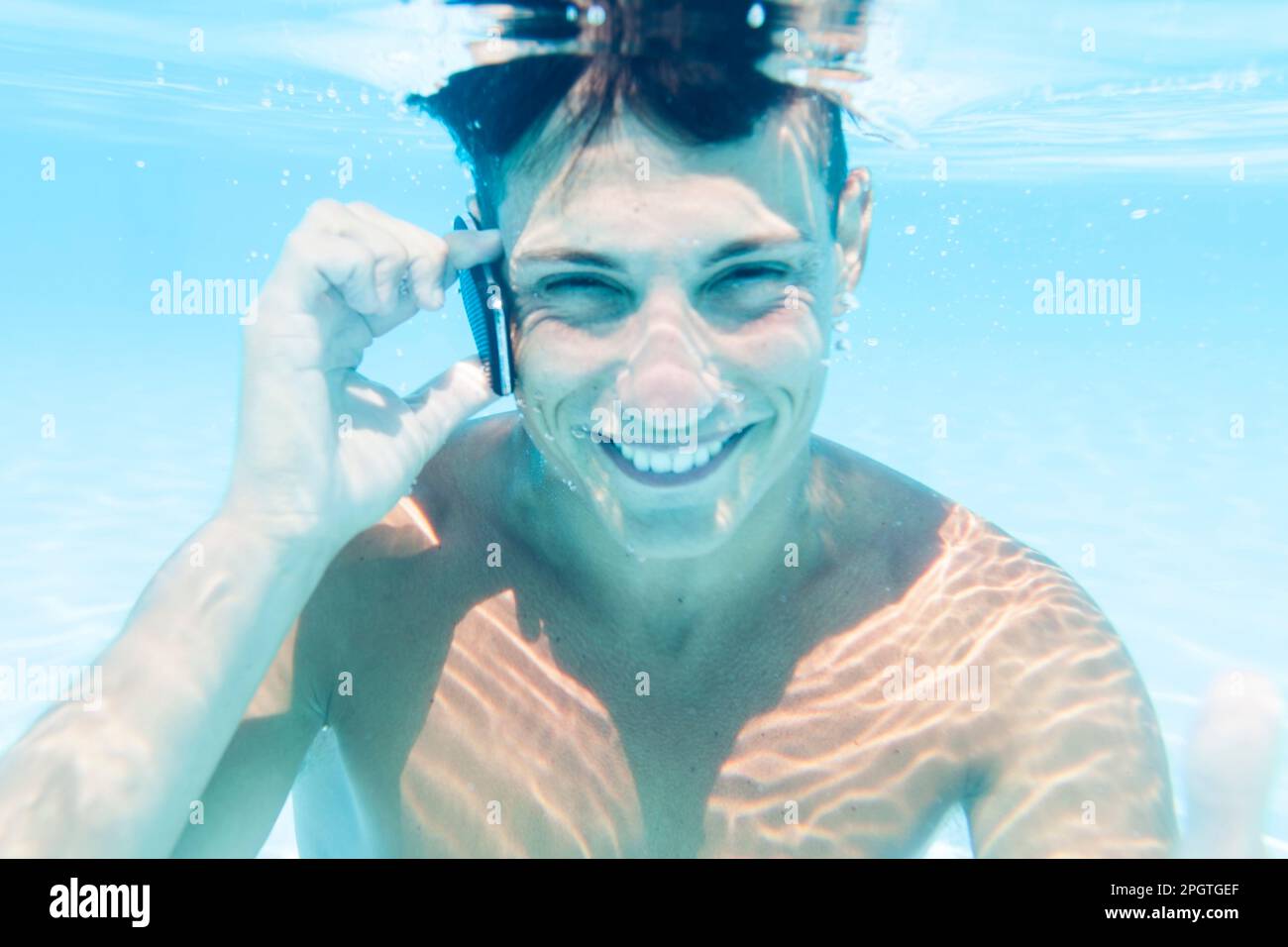 young man takes a call to smartphone underwater Stock Photo - Alamy