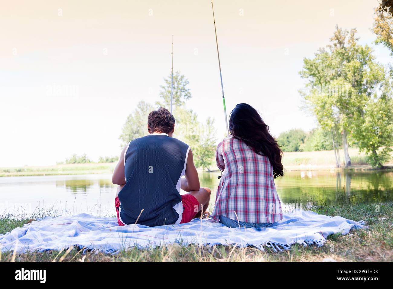 young couple fishing on the banks of the pond Stock Photo - Alamy