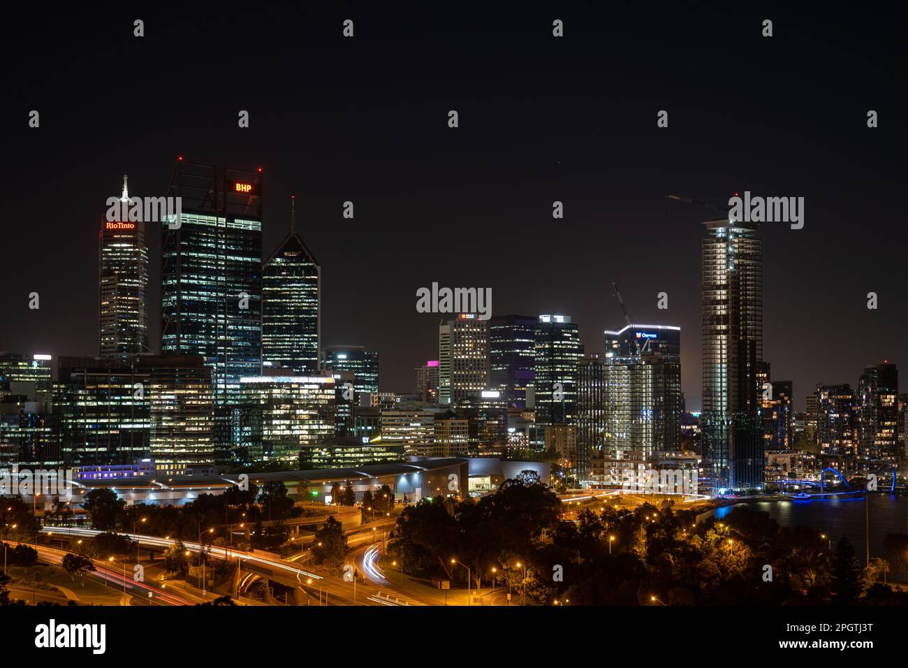 Brightly lit city buildings illuminated in the night time, creating a ...