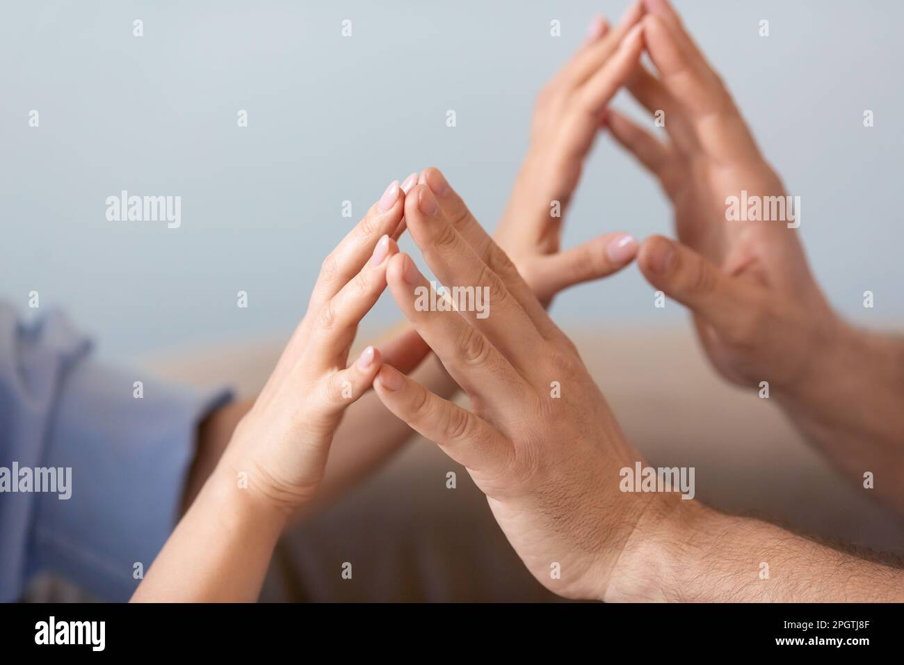 A close-up photo of a couple's hands, gently touching each other's ...