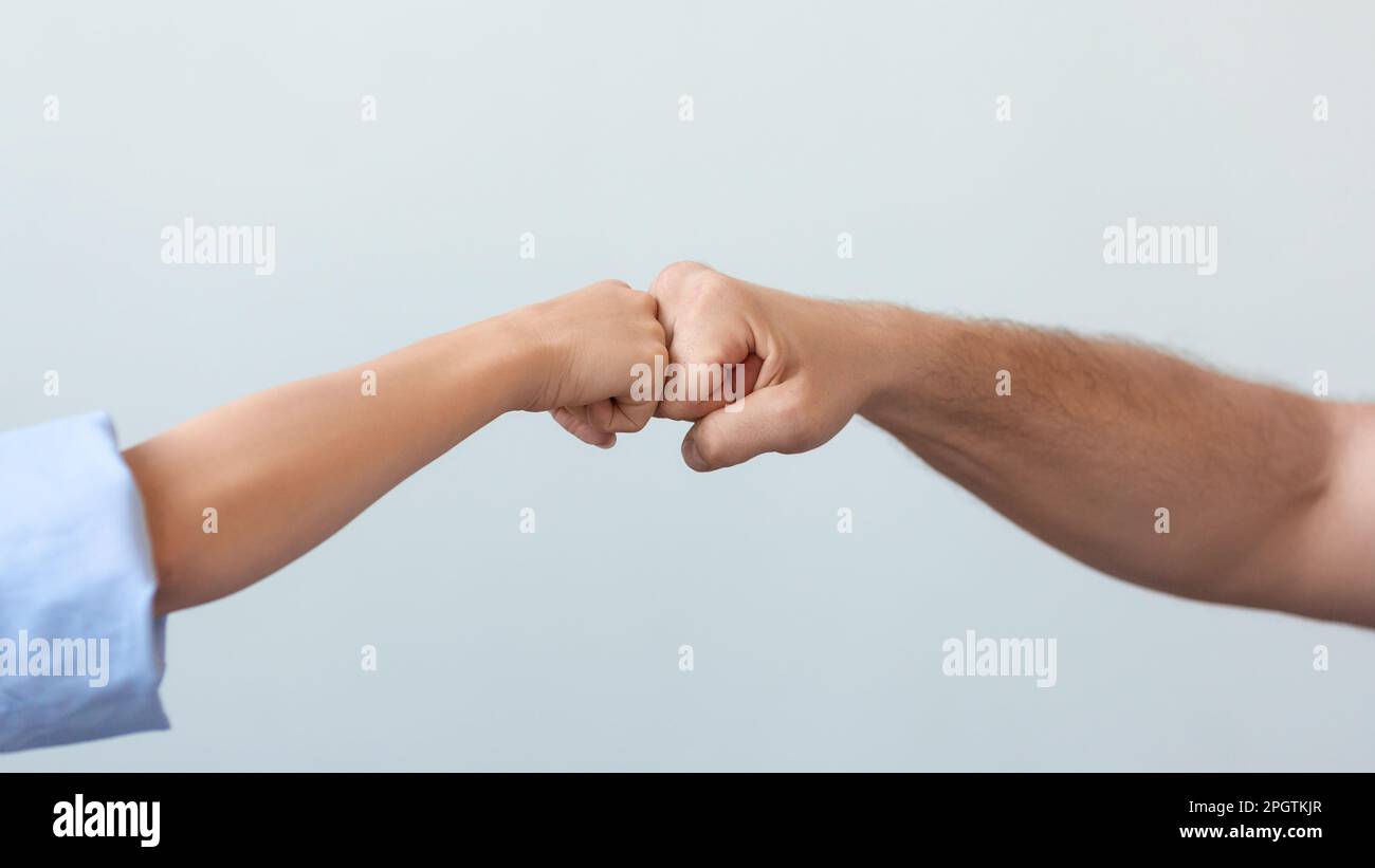 Close-up of a couple's hands with fists clenched in opposition ...
