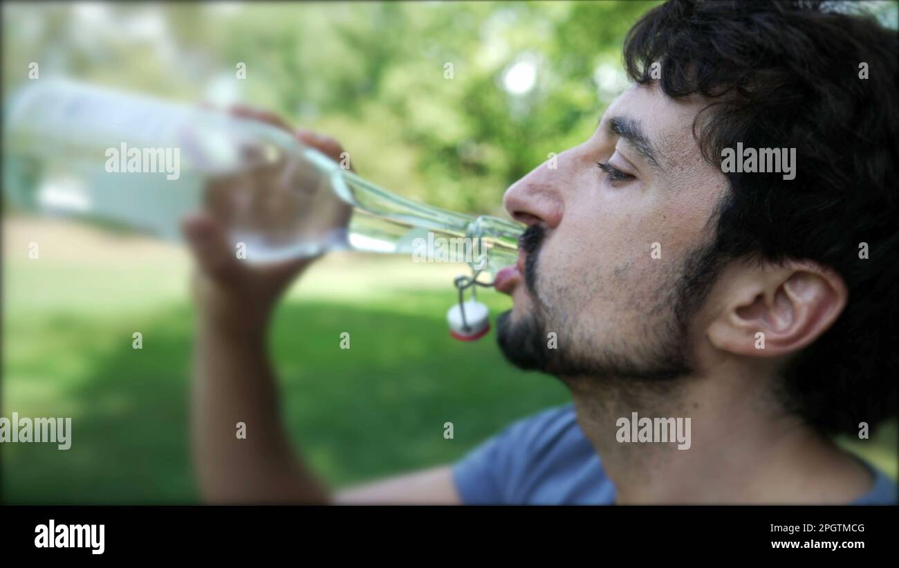 Thirsty Man drinking refreshing water outside at park. Profile of ...