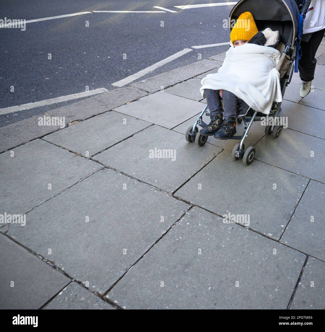 London, England, UK. Young child in a pushchair wrapped up warm in ...