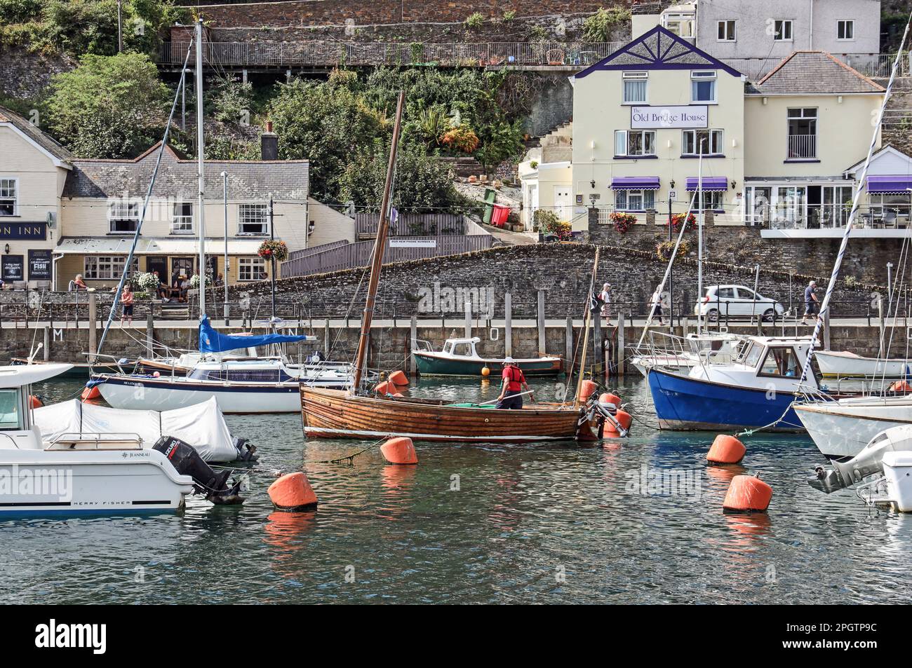 Boat maintainance. Berthed boats on the River Looe near to the bridge ...