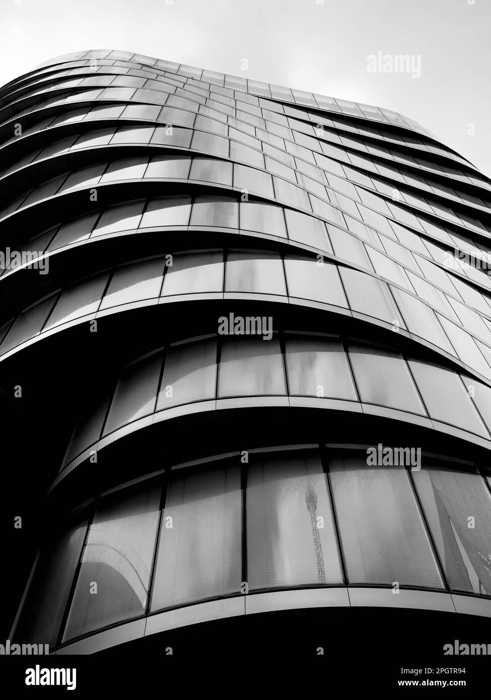 A grayscale shot of a modern building with wavy windows Stock Photo - Alamy