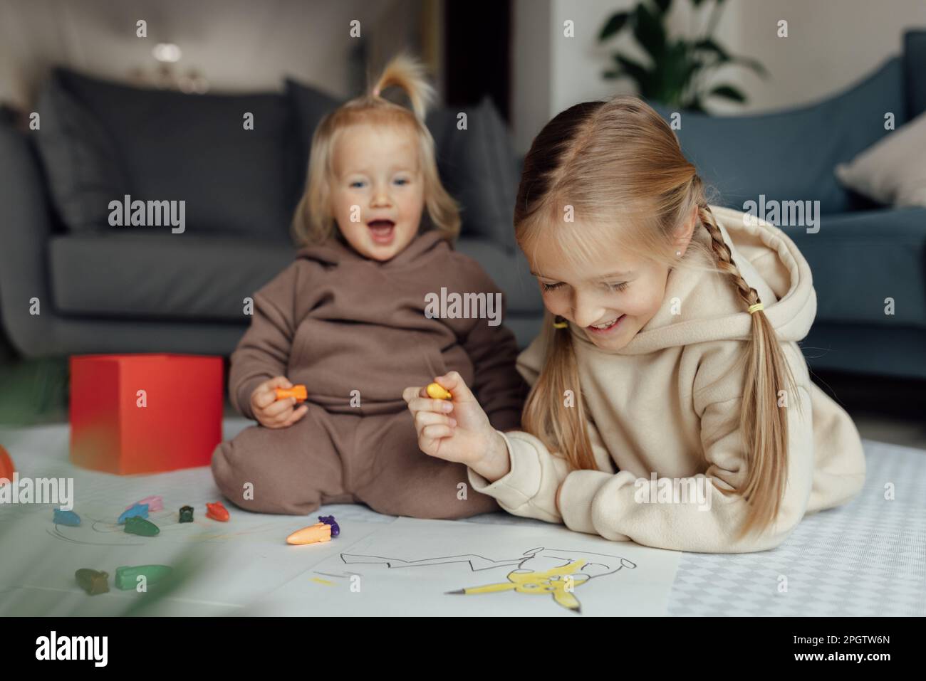 Little caucasian siblings drawing together on floor in living room at ...