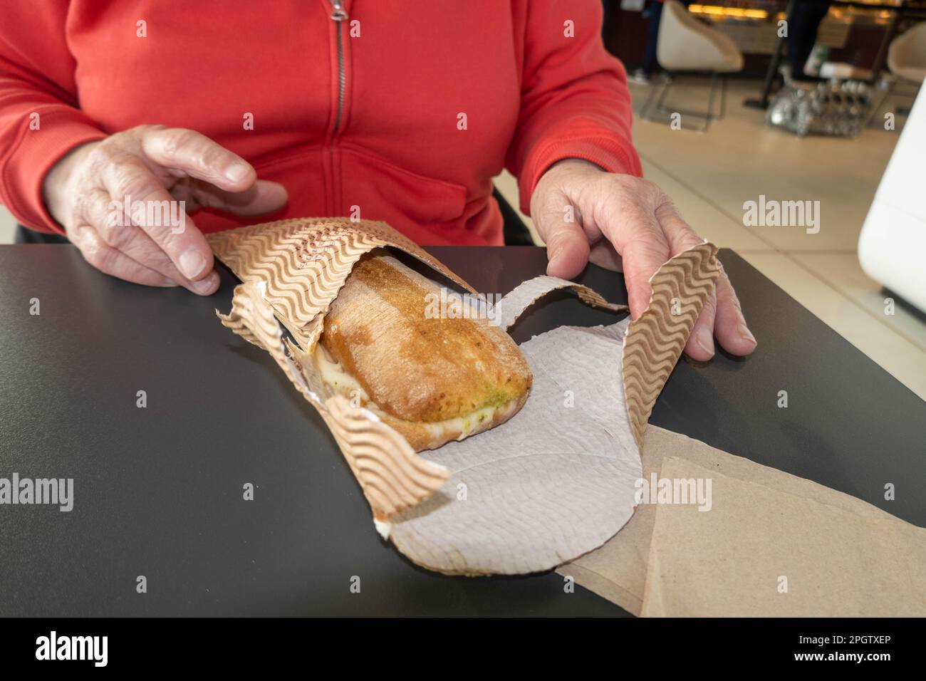 lady unwrapping a hot Mozzarella and Tomato Panini in a Costa coffee ...
