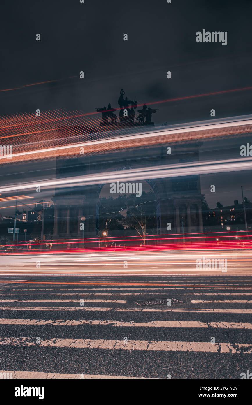 An urban street scene at night, with car headlights and taillights ...