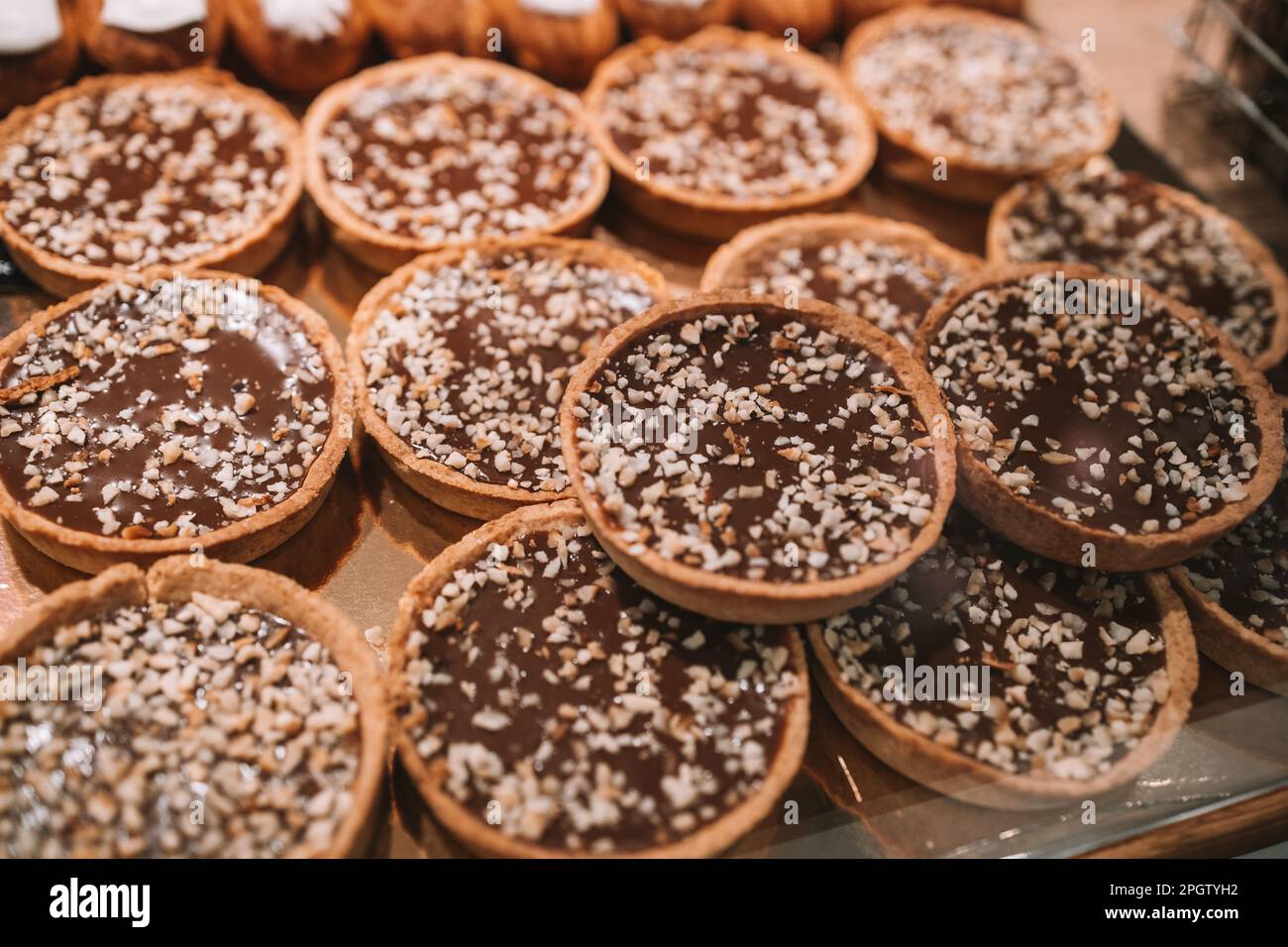 a display case filled with lots of different types of cakes and pies on ...