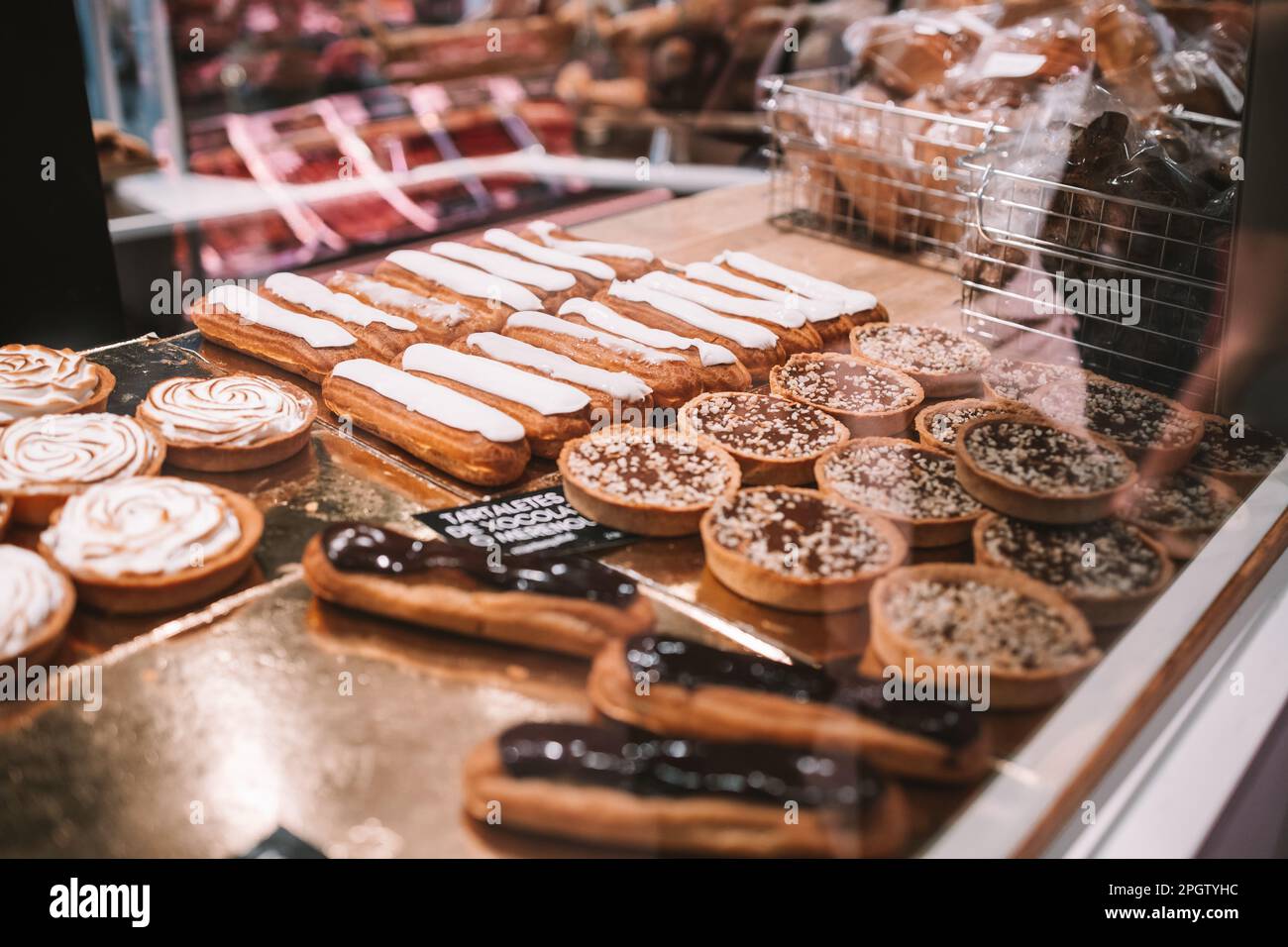 a display case filled with lots of different types of cakes and pies on ...
