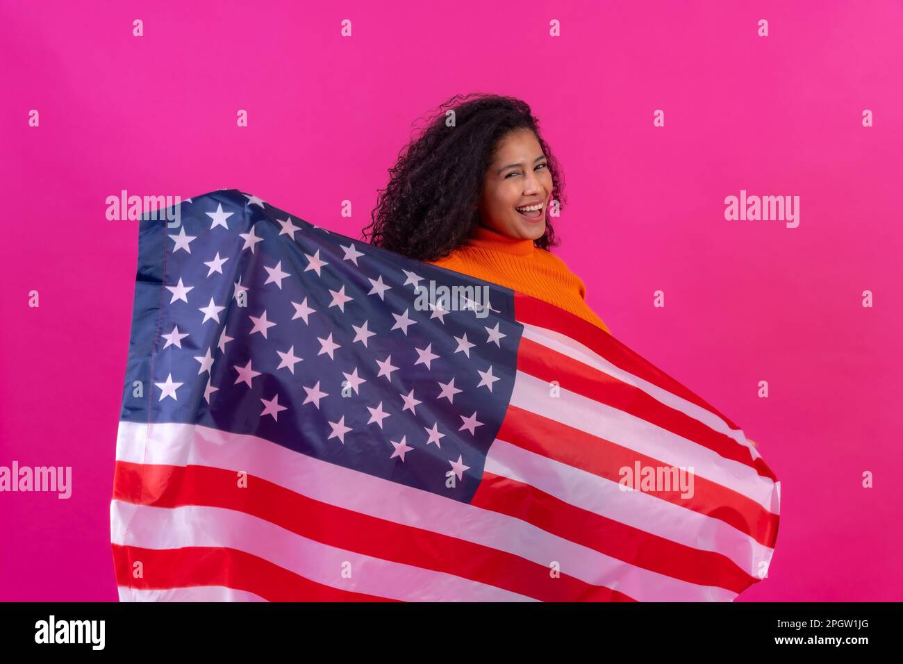 A cheerful Hispanic female with curly hair demonstrating the American ...