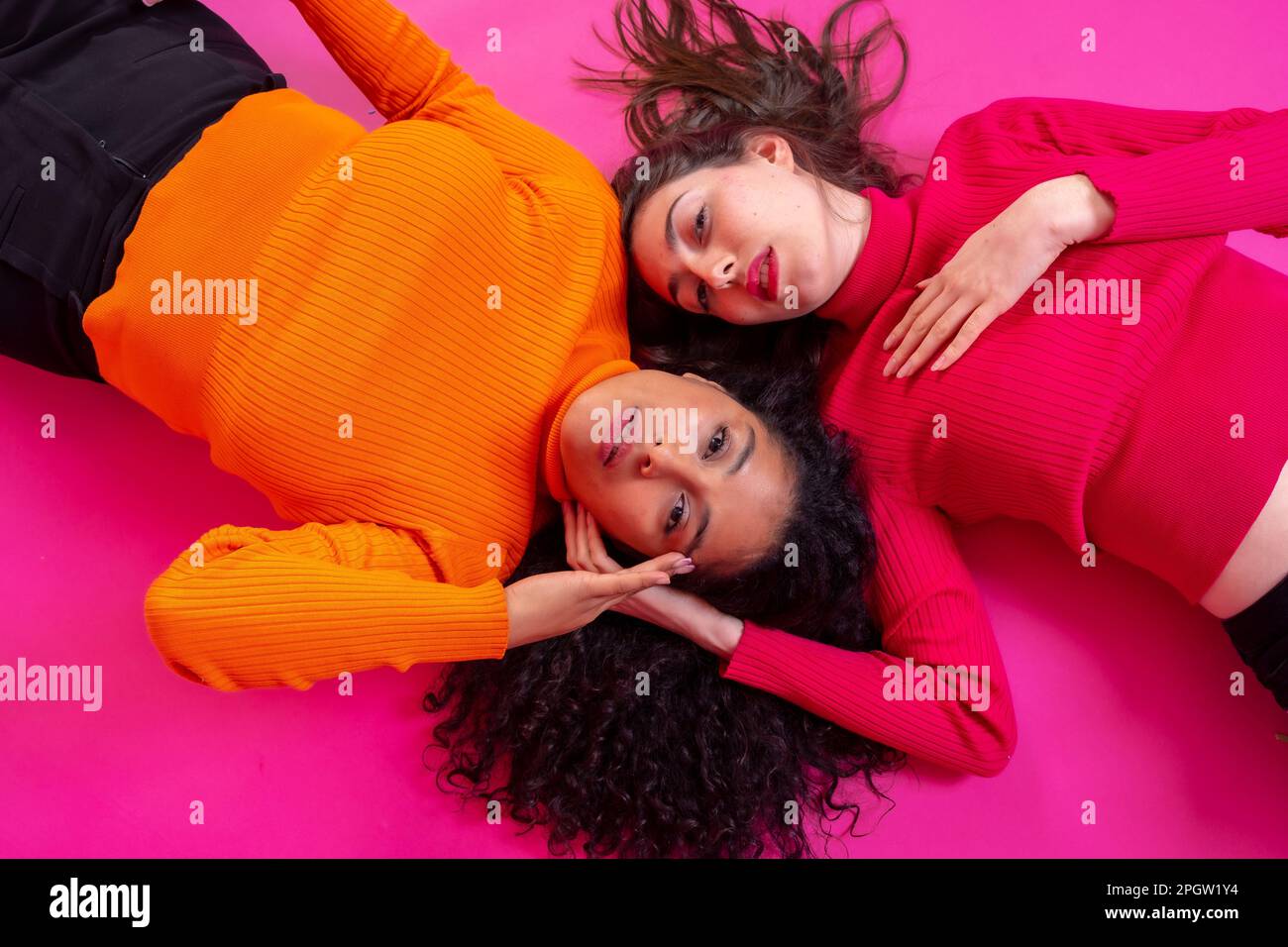 Two cheerful female friends wearing matching outfits posing for the ...