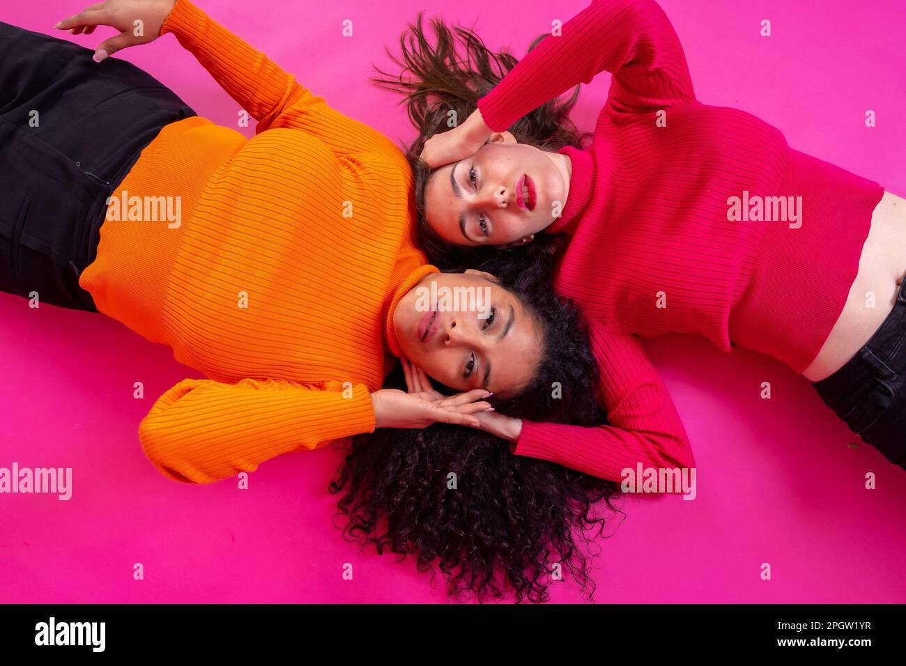 Two cheerful female friends wearing matching outfits posing for the ...