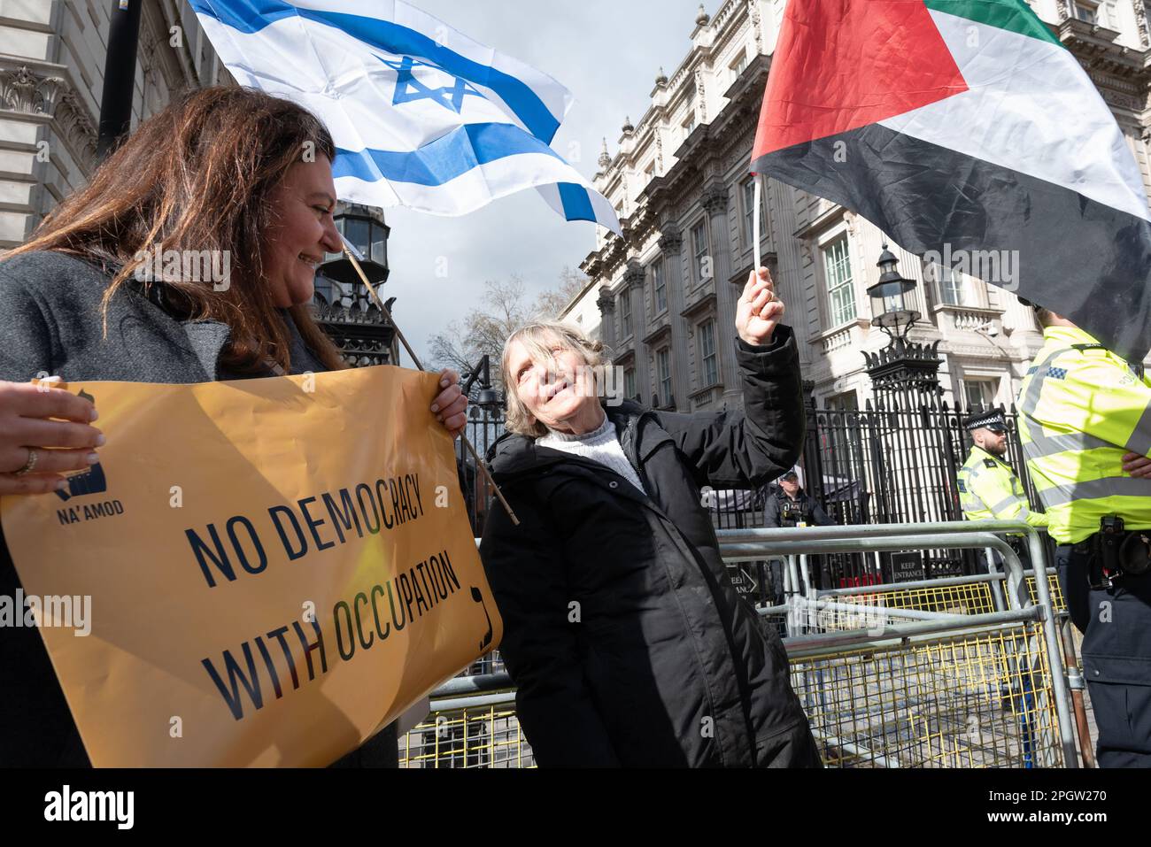 Women waving Israeli and Palestinian flags chat during a protest in ...