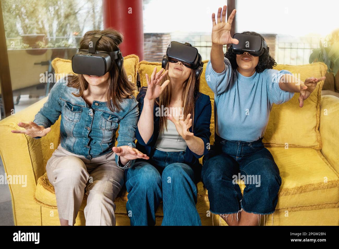 Three young women, two Caucasian and one Brazilian, aged 20-30, sitting ...