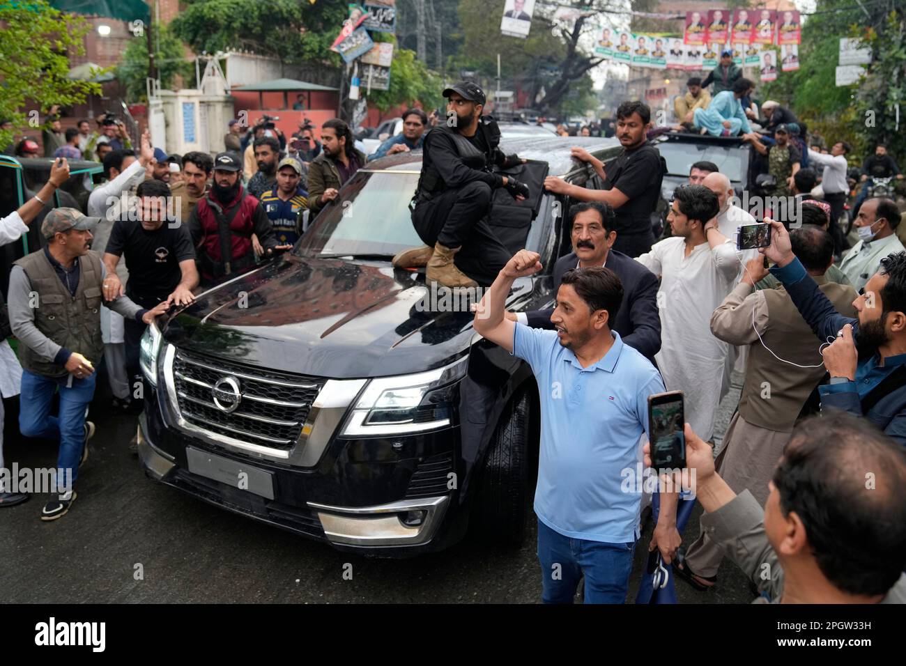 Security personnel escort a vehicle carrying former Prime Minister Imran Khan as he leaves after ...