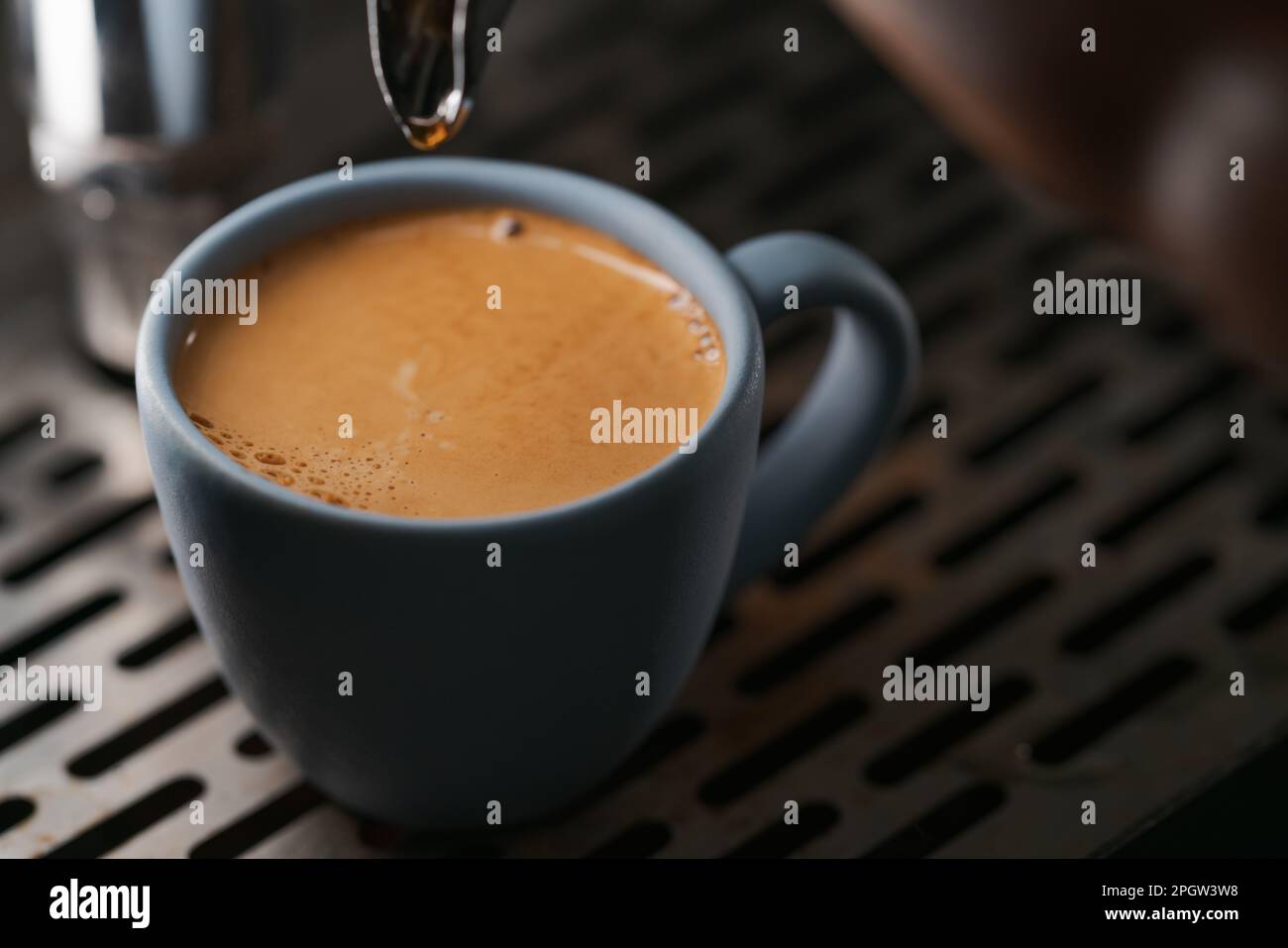 Closeup espresso last drop with single spout portafilter in blue cup ...