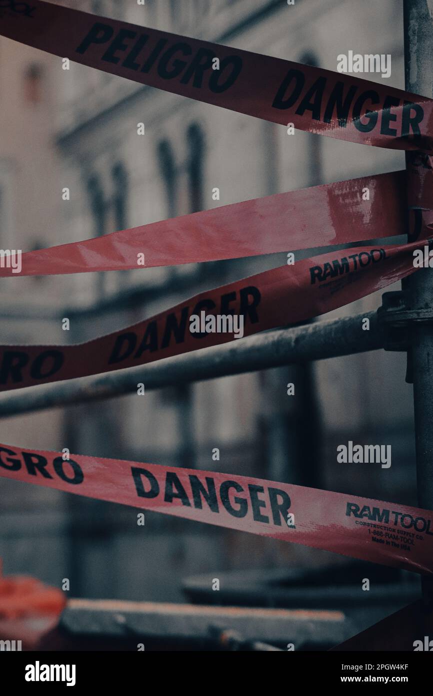 A vivid red construction caution tape is stretched out in front of a ...