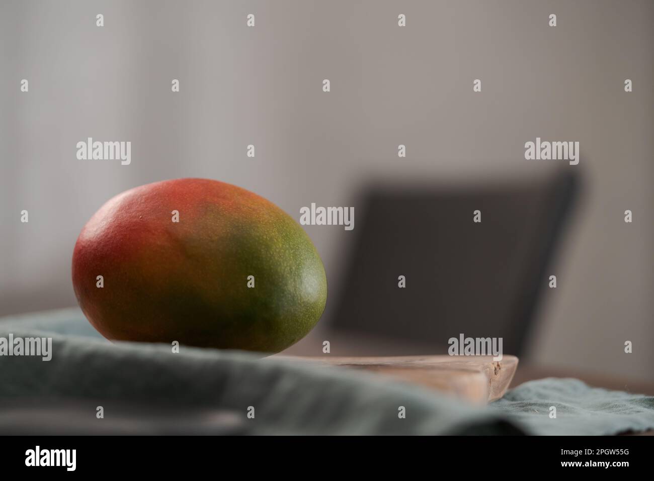 Whole ripe red mango on olive wood board, shallow focus Stock Photo - Alamy