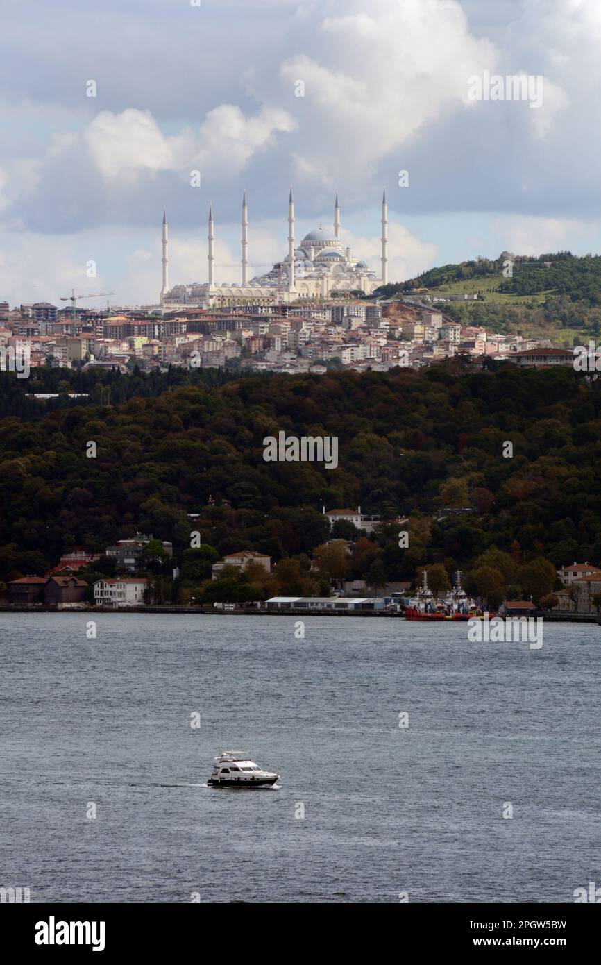 A motorboat and yacht travelling across the Strait of Bosphorus, near ...